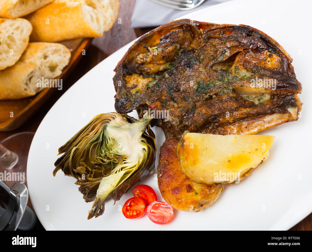 Cabeza de cordero - spanish dish. Lamb head with artichoke, tomatoes ...