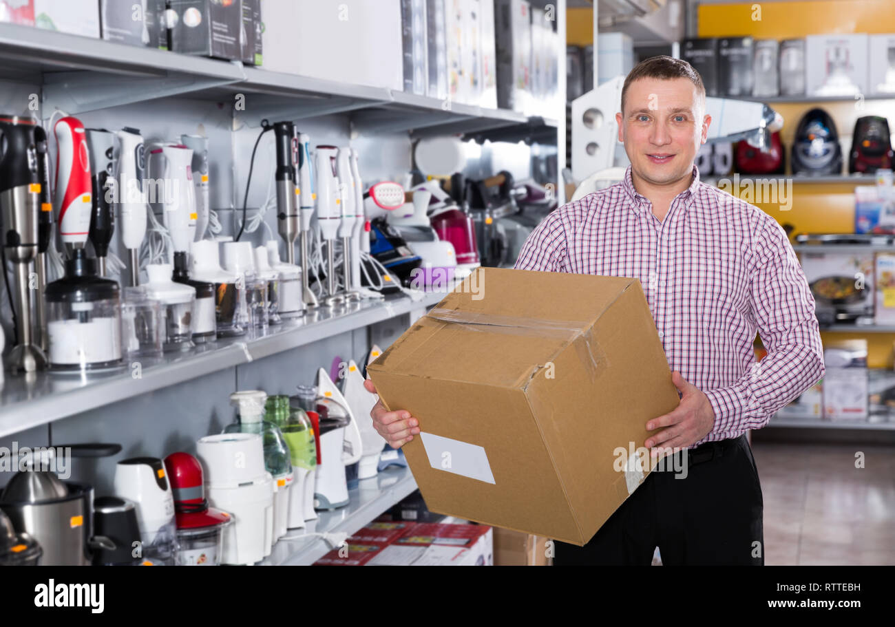 man customer with packed purchases in household appliances section in ...