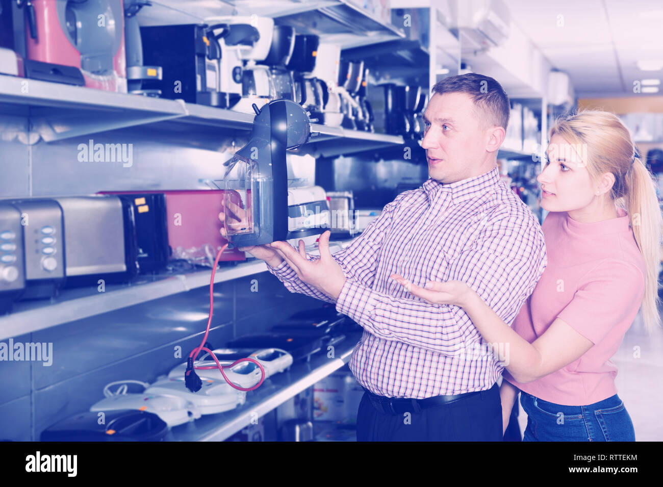 Family couple buying modern coffee machine for kitchen in household ...