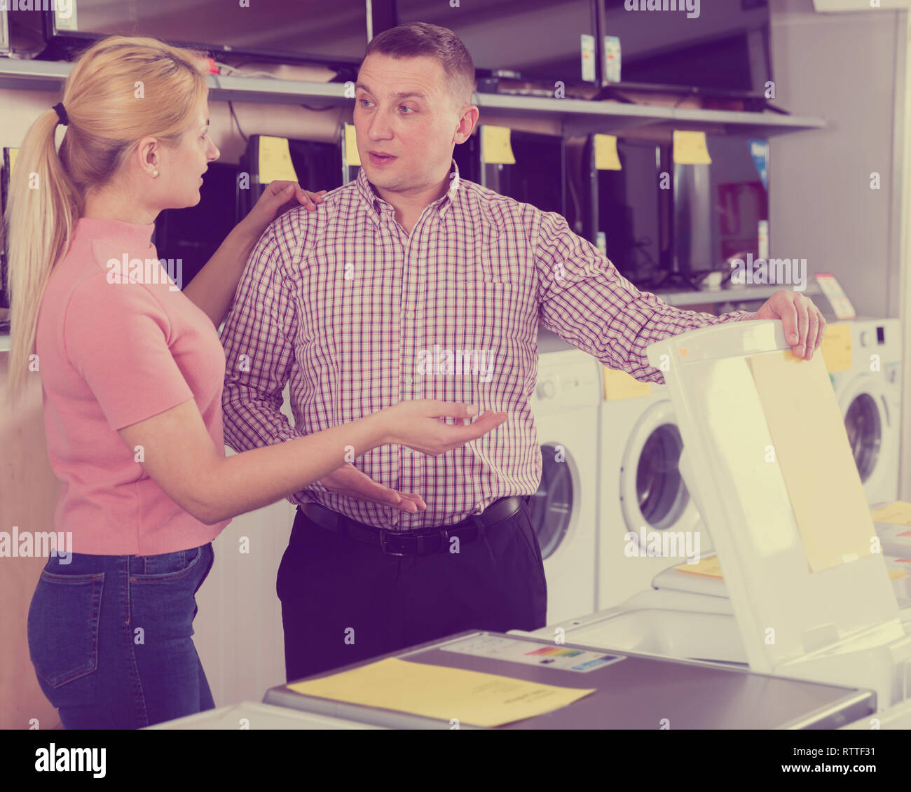 Positive family chooses washing machine in shop of household appliances ...