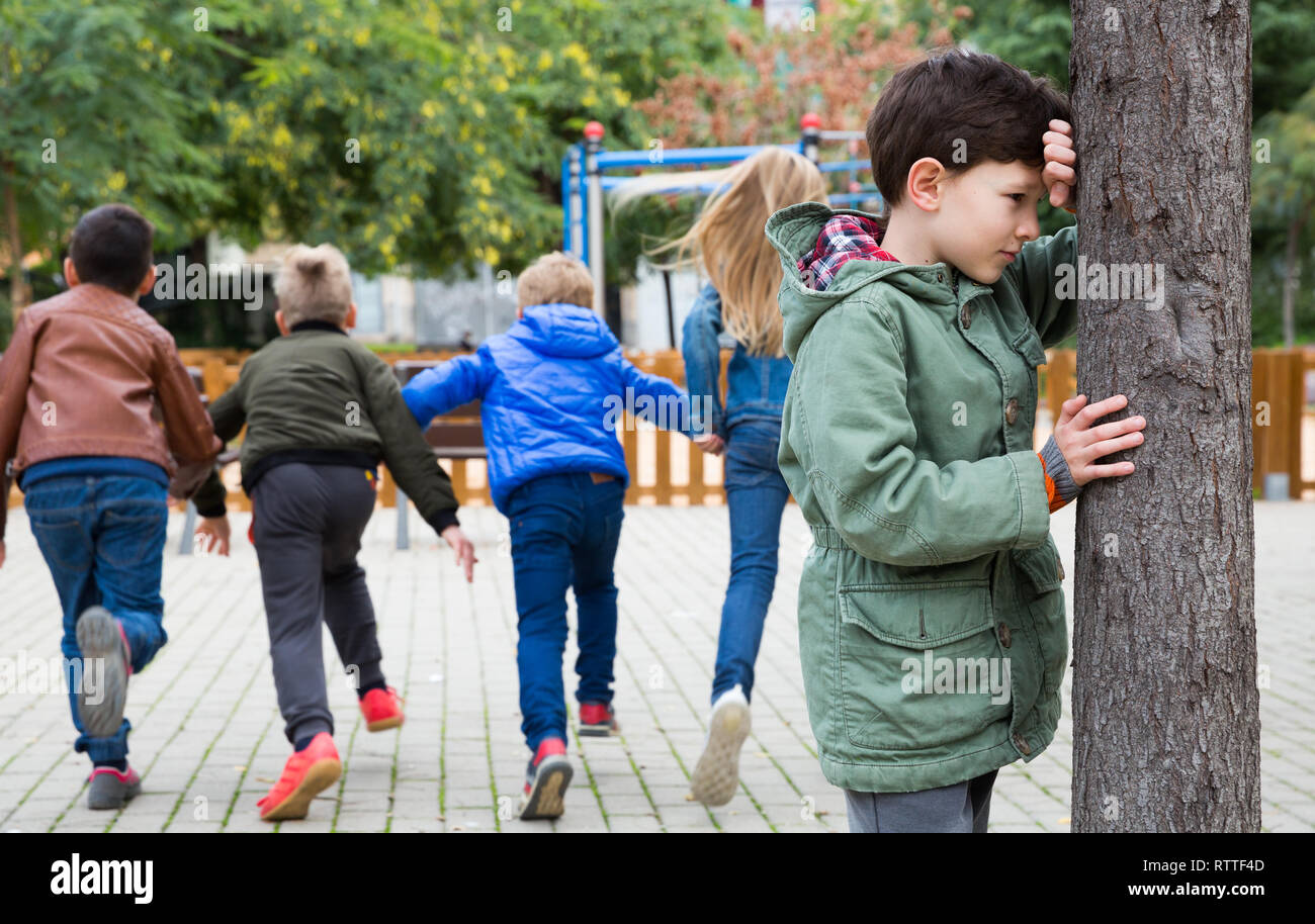 Hide and seek. Preteen boy closing his eyes and counting while other ...
