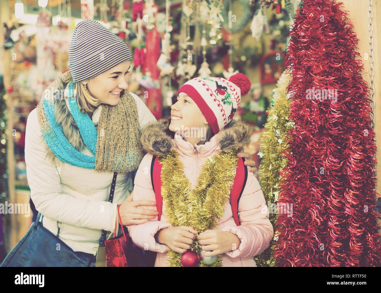 Smiling female customers staring at counter of Christmas market. Focus ...
