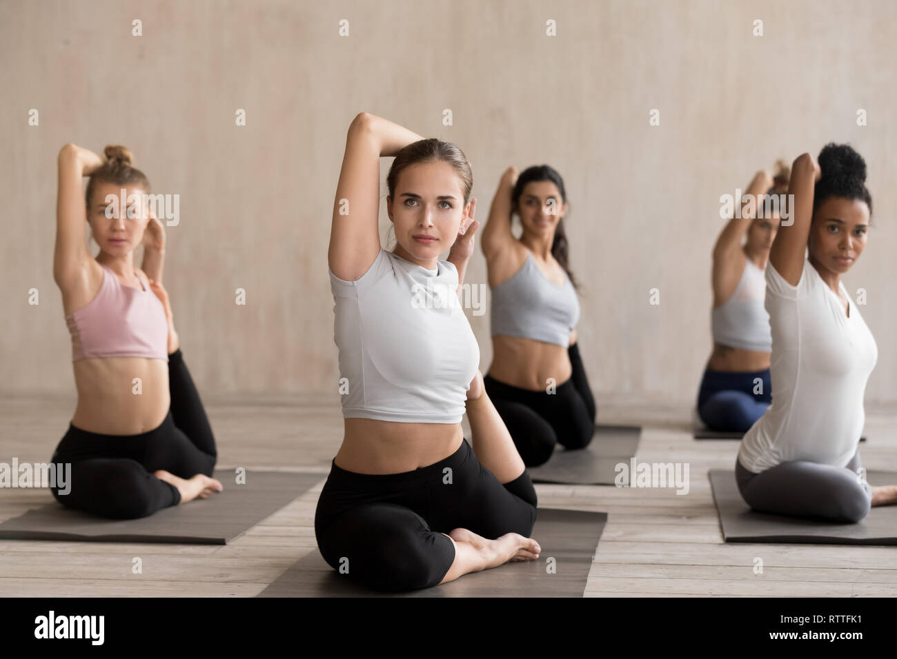 Group of young people practicing yoga lesson doing Mermaid pose Stock ...