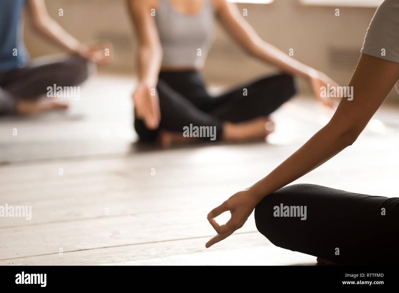 Group of people practicing yoga lesson with instructor, Ardha Padmasana ...