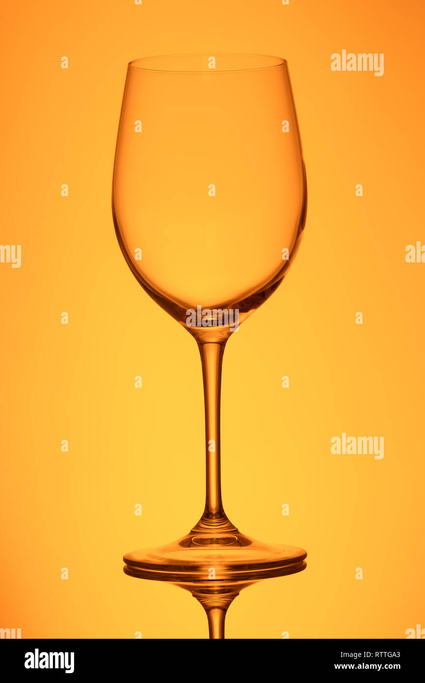 White wine glass for burdundy chardonnay empty in orange back lit Stock ...