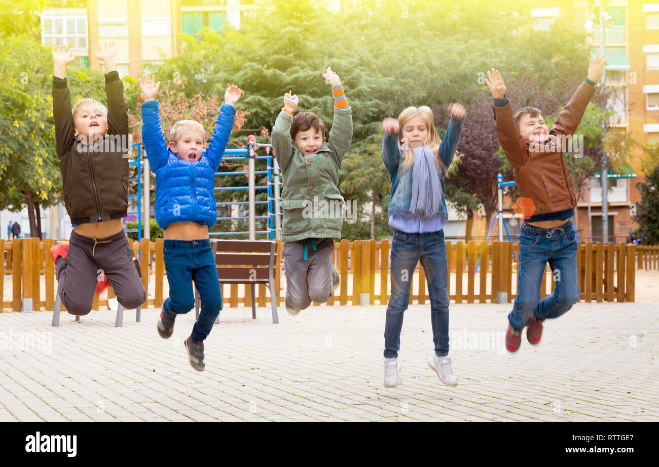 Happy kids jump and play outside Stock Photo - Alamy