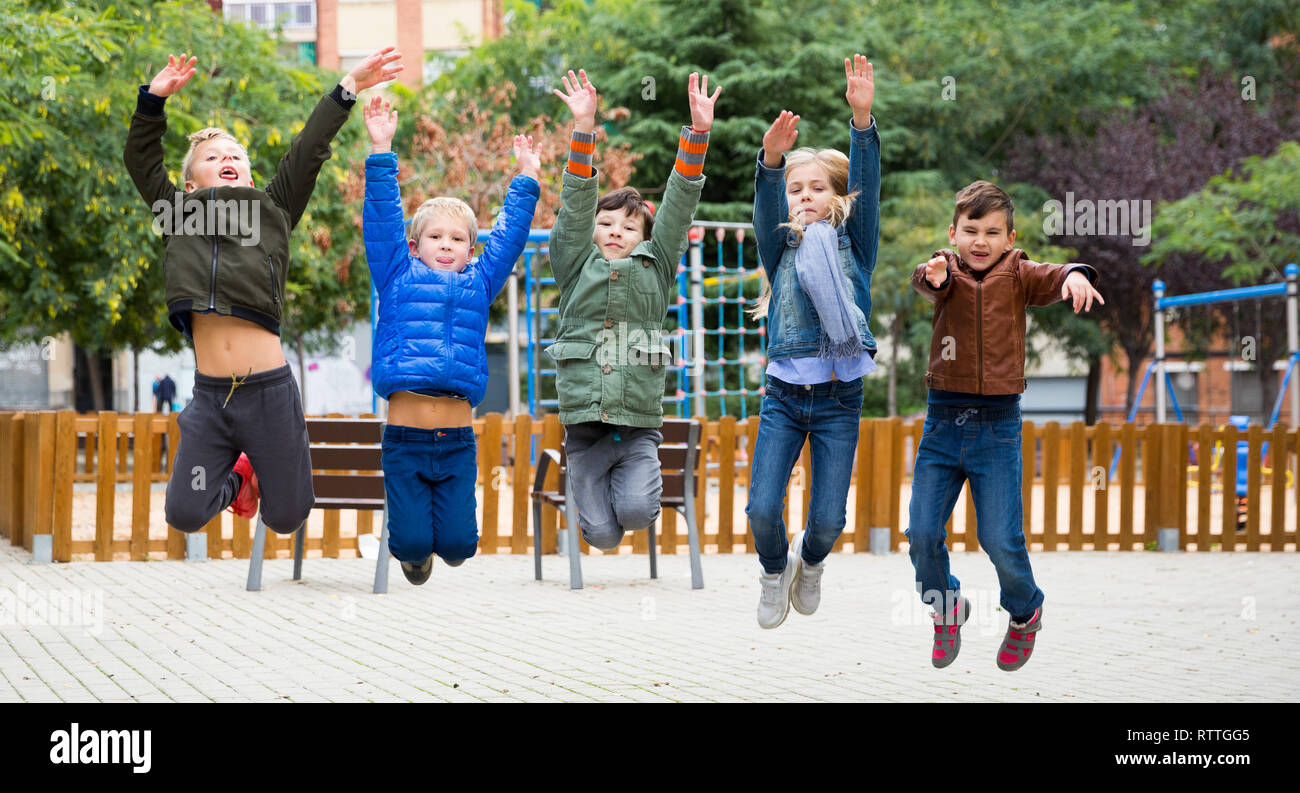 Happy kids jump and play outside Stock Photo - Alamy