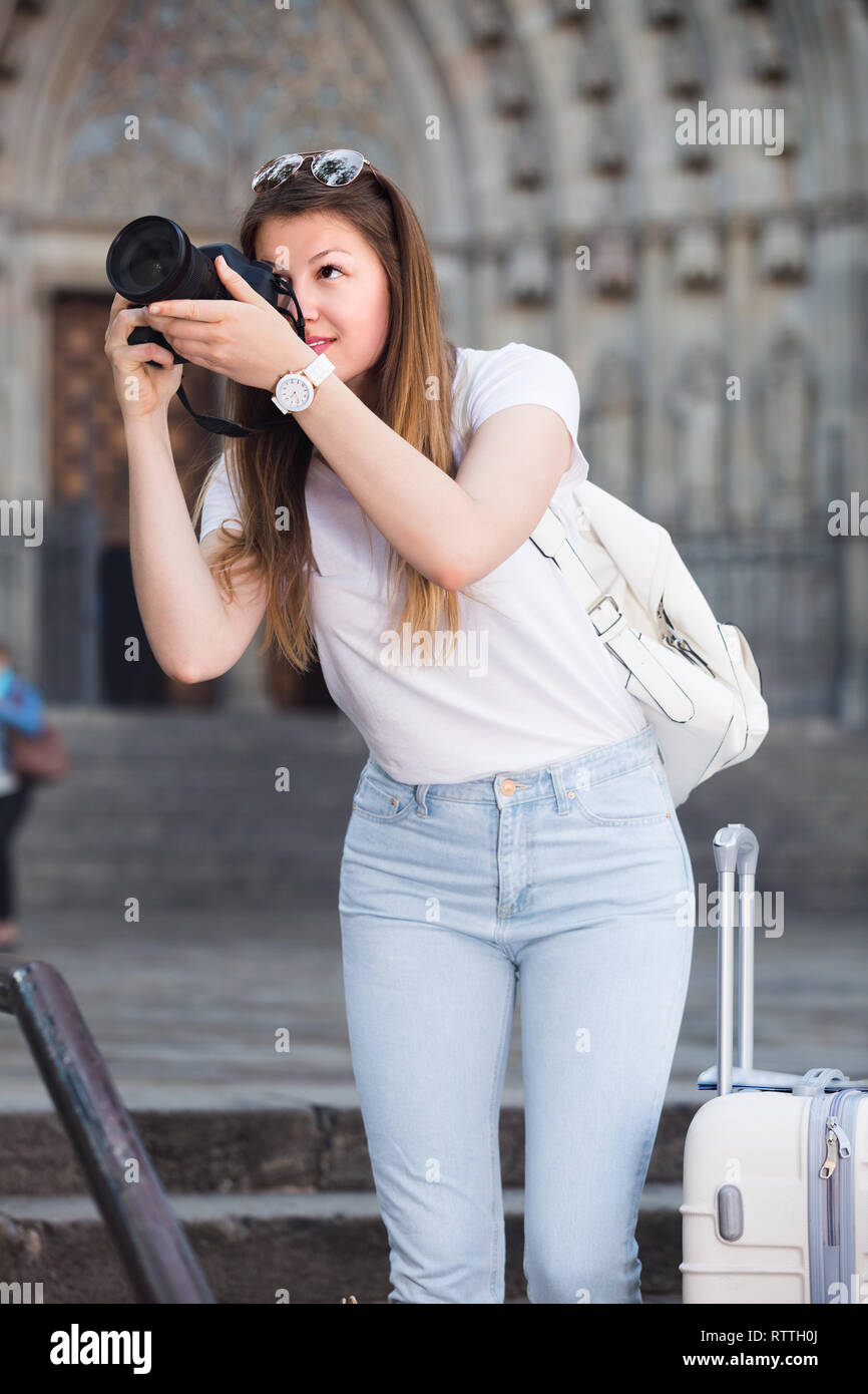 Girl is taking photos on her camera while journey through the city ...
