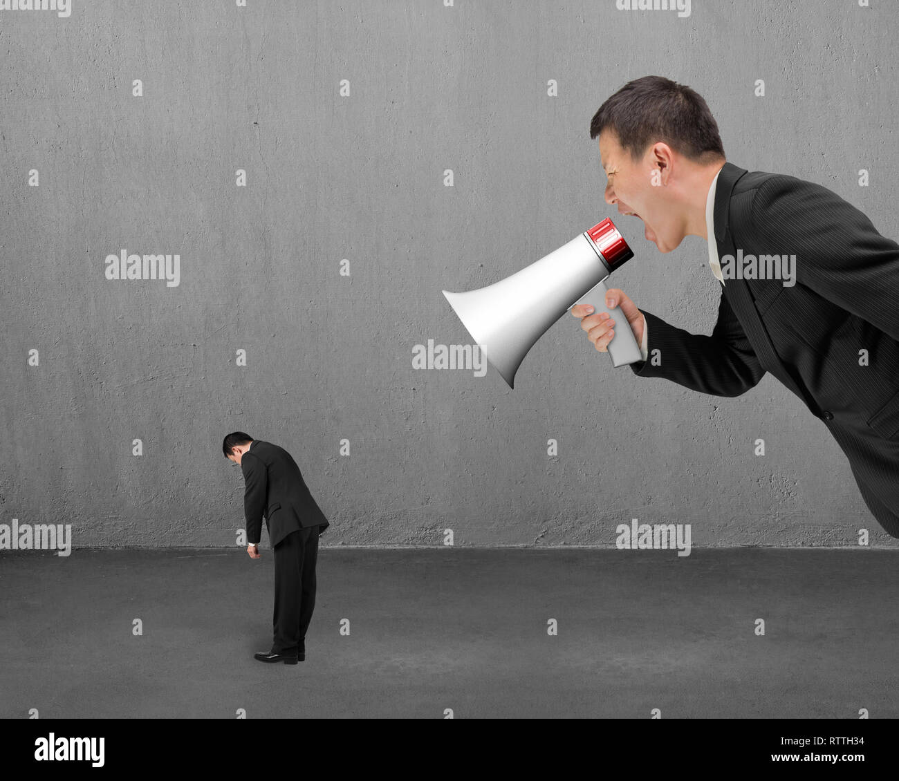 Businessman using megaphone yelling at his employee with concrete room ...