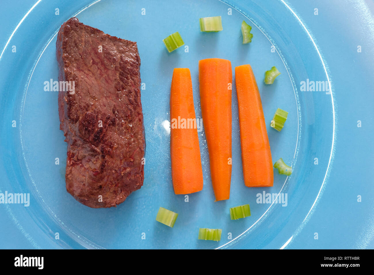 Fried ostrich meat with carrots and celery as top view Stock Photo - Alamy