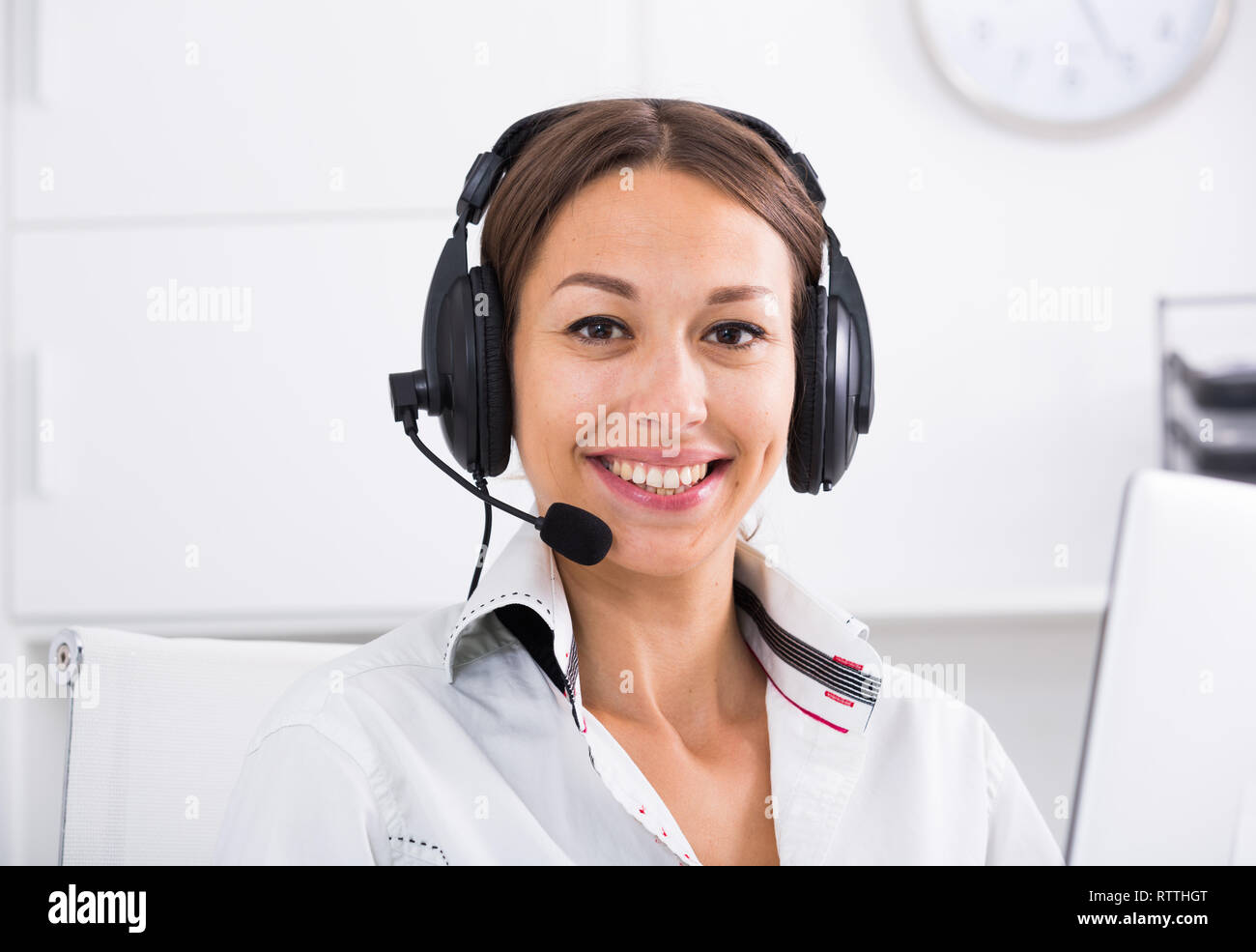 positive woman talking with customer using hands-free set at call ...