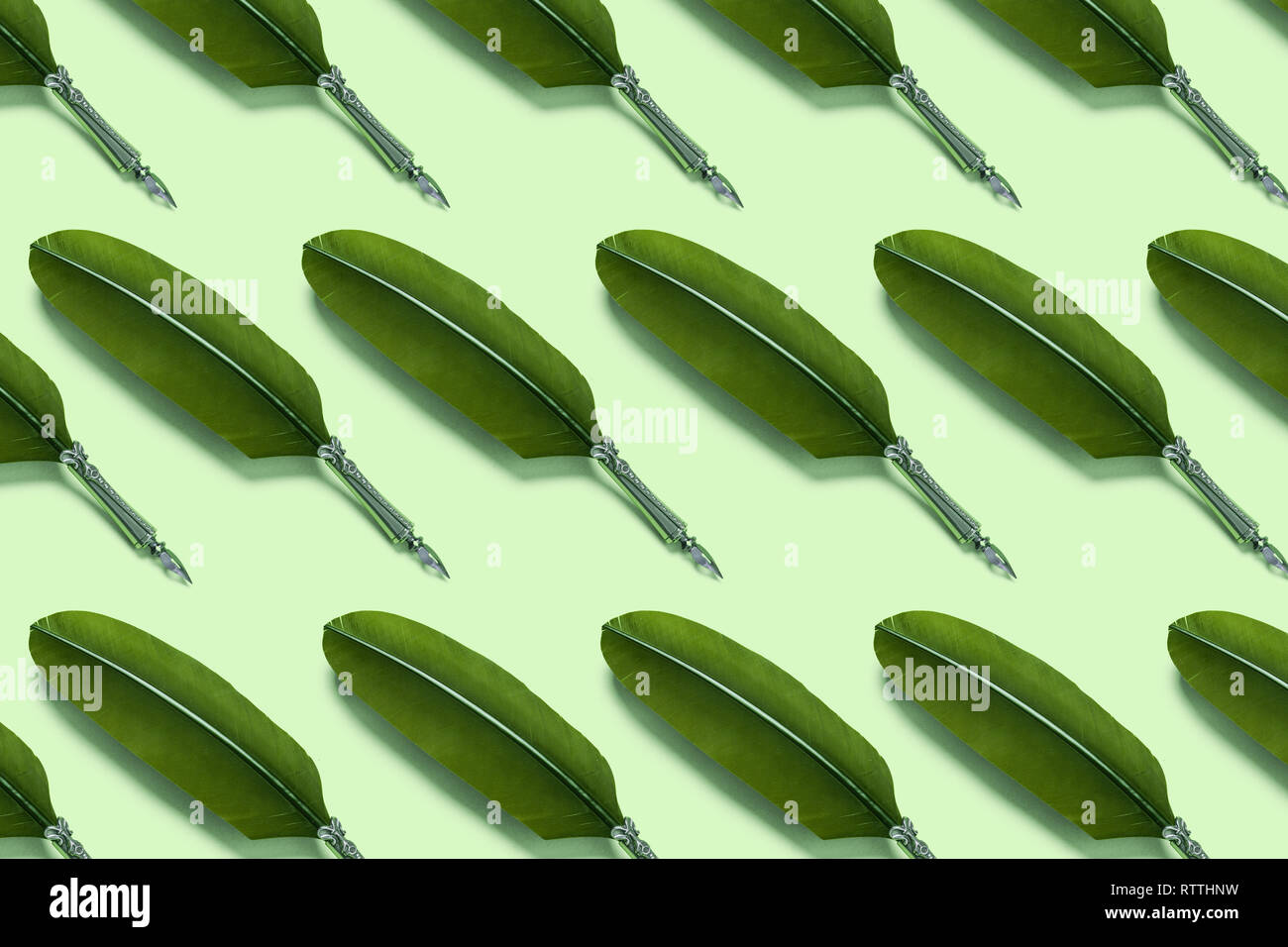 Green quill pens organized in a row over light green background Stock ...