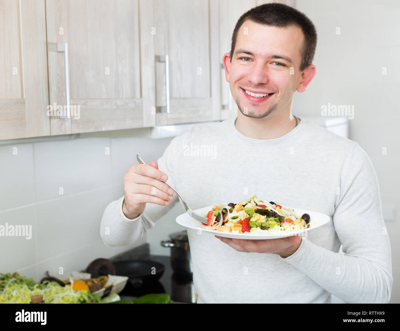 Happy adult guy having healthy lunch with veggies in home Stock Photo ...