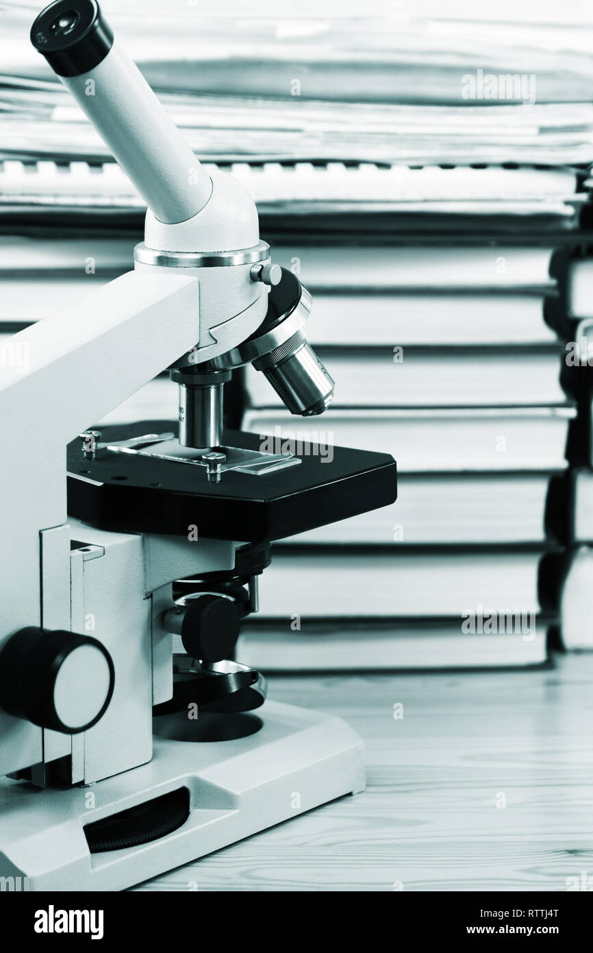 Scientific study with the microscope and books Stock Photo - Alamy