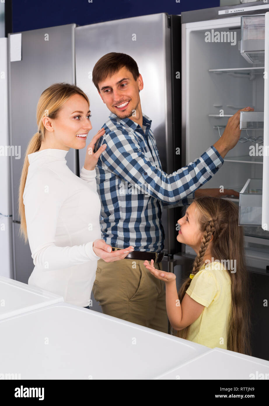 happy family selecting new refrigerator in appliance store Stock Photo ...