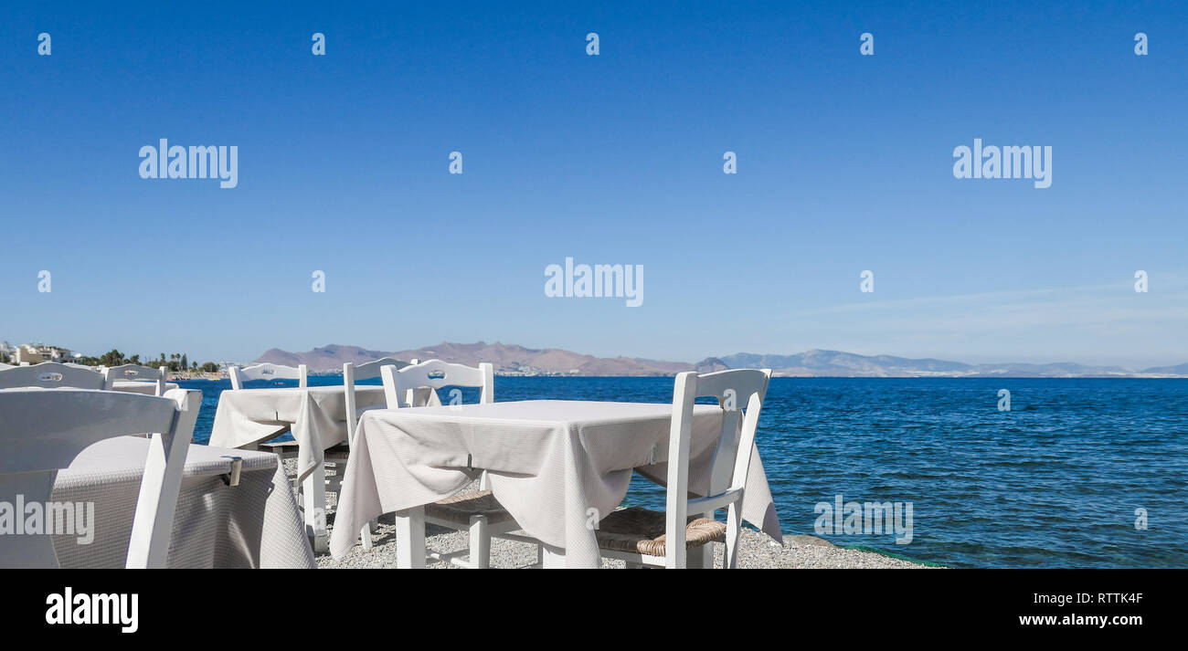 White restaurant tables on the beach in summer - travel, vacation and ...