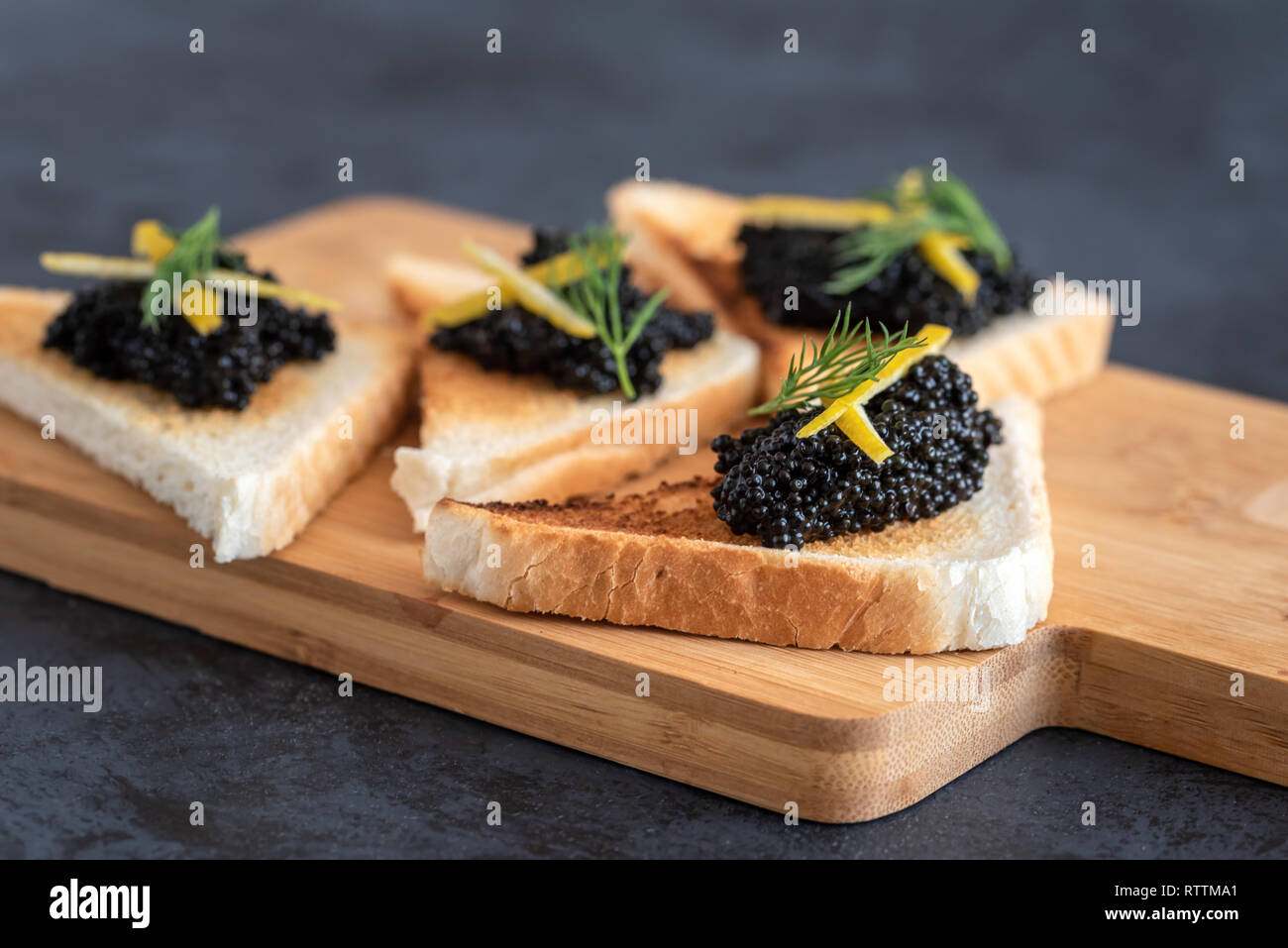 Appetizer toast bread with black caviar decorated by lemon pill and ...