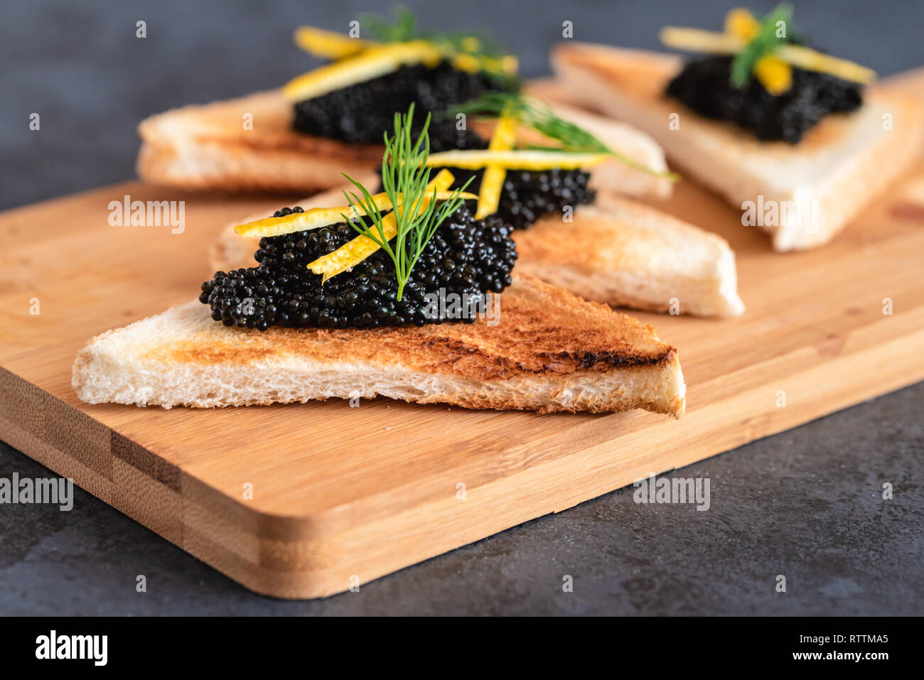 Appetizer toast bread with black caviar decorated by lemon pill and ...