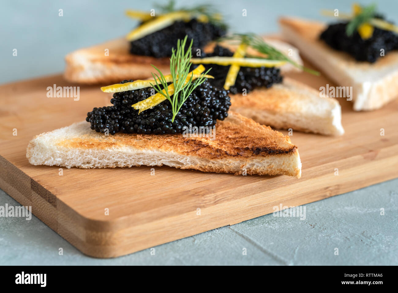 Appetizer toast bread with black caviar decorated by lemon pill and ...