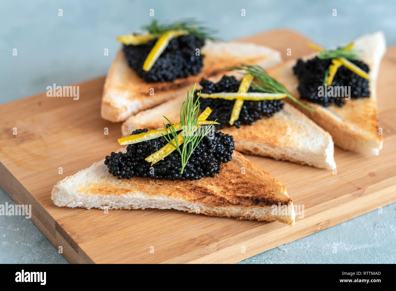 Appetizer toast bread with black caviar decorated by lemon pill and ...