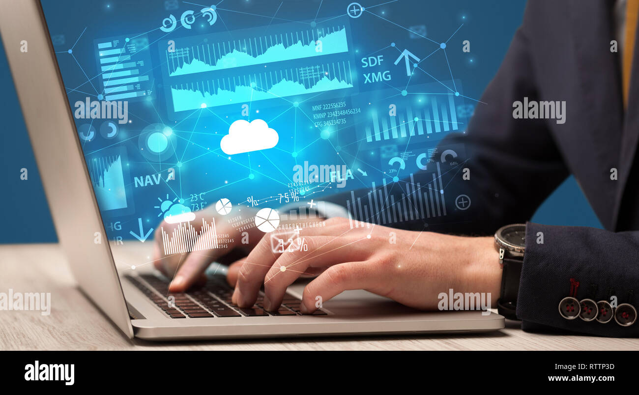 Businessman hand typing on laptop with reports and graphs concept ...