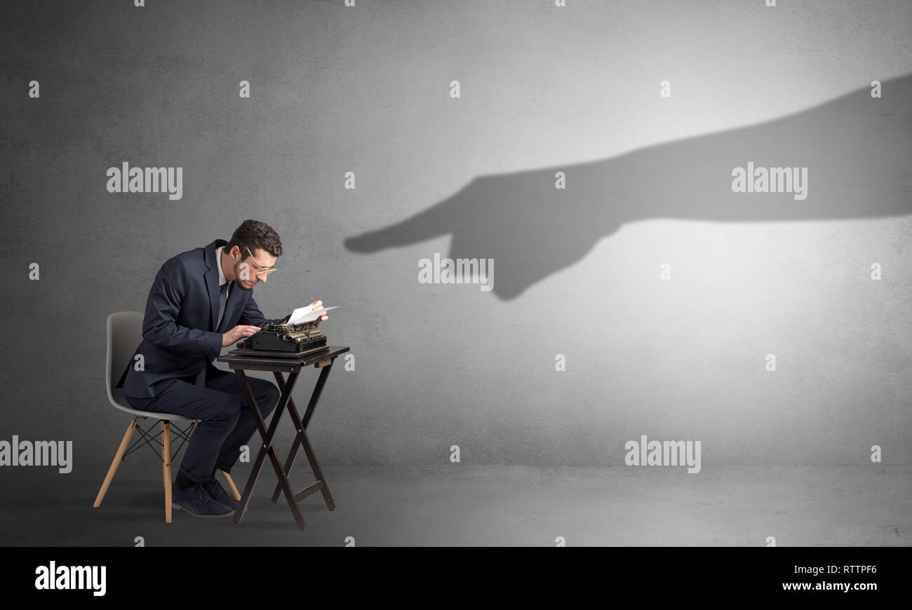 Shadow hand pointing at a small afraid worker Stock Photo - Alamy