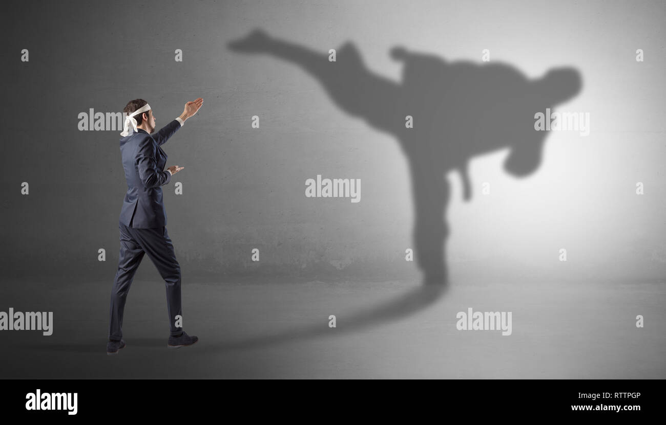 Businessman fighting with his strong karate man shadow Stock Photo - Alamy