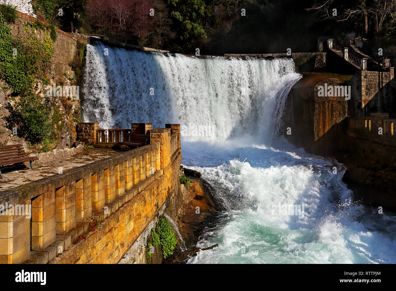 Mountain river enclosed in stone embankments when it enters the ...
