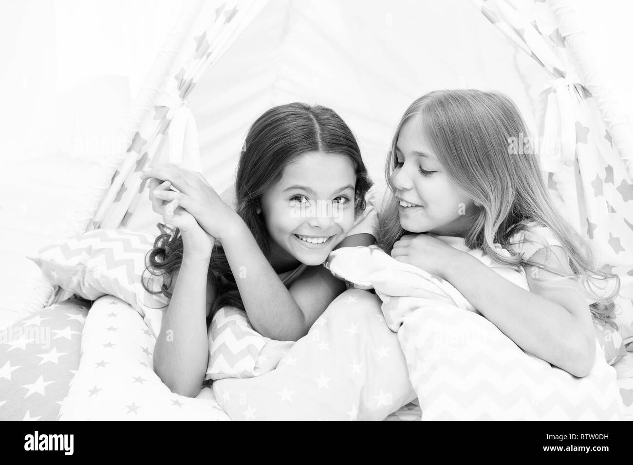Sisters share gossips having fun at home. Pajamas party for kids. Cozy ...