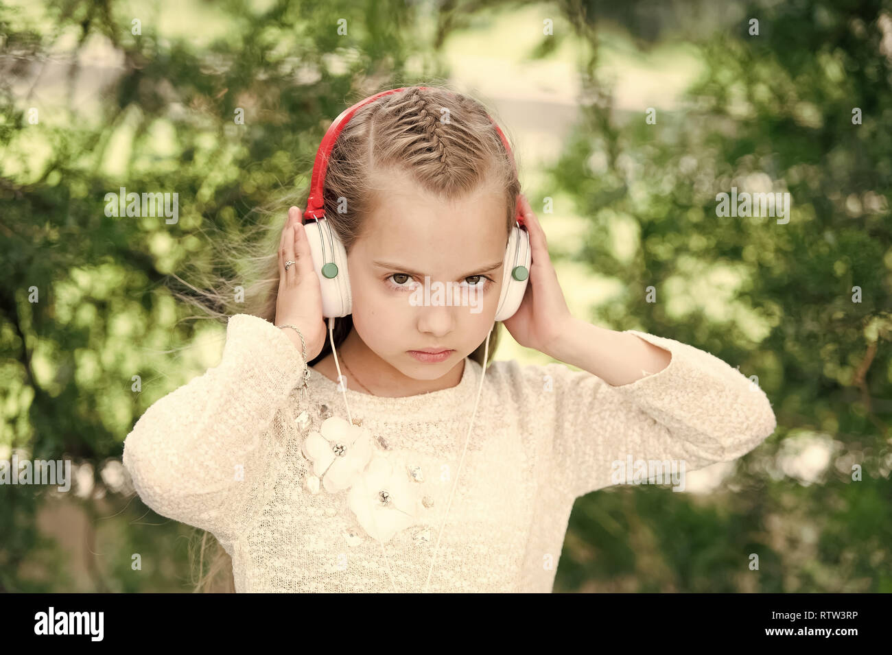 Cute little girl enjoying music using headphones at summer day Stock ...