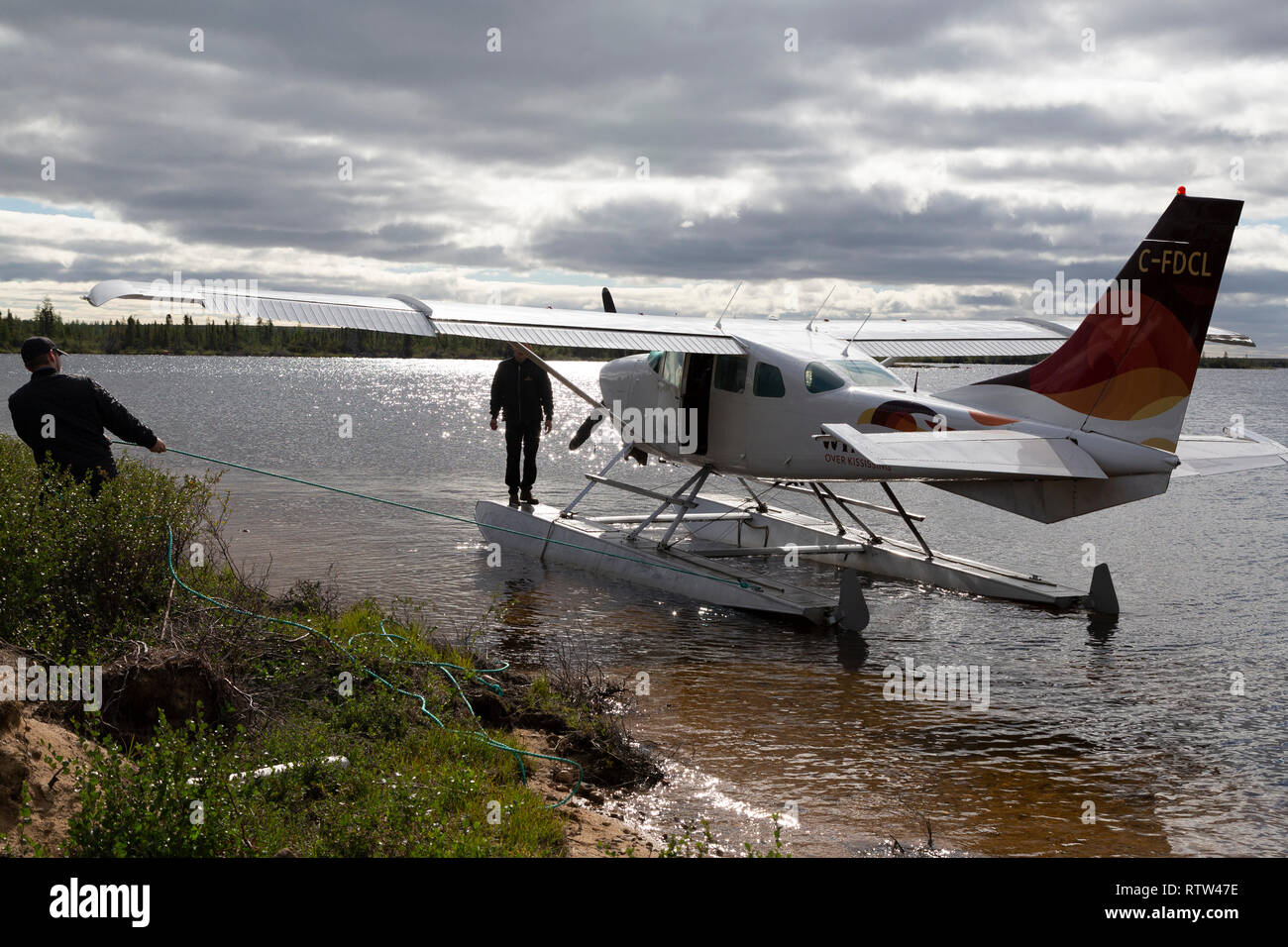 Pilots tether a float plane on a lake in Manitoba, Canada. The aircraft ...