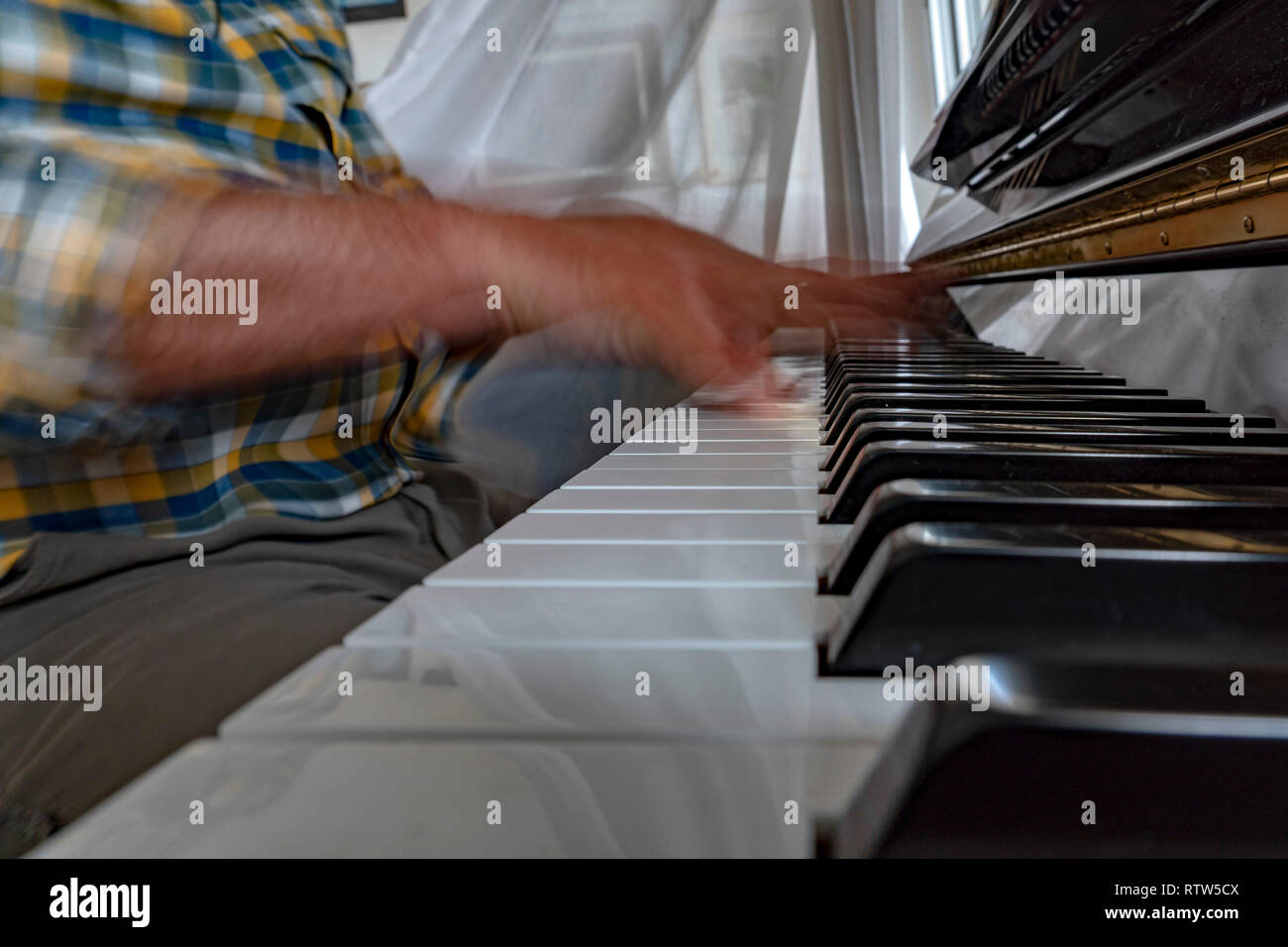 Hands playing piano while moving move effect close up Stock Photo - Alamy
