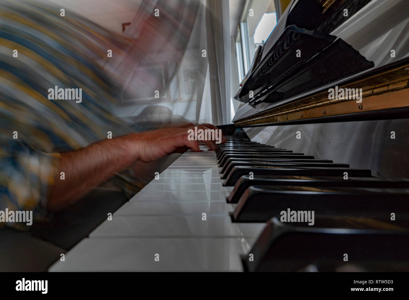 Hands playing piano while moving move effect close up Stock Photo - Alamy