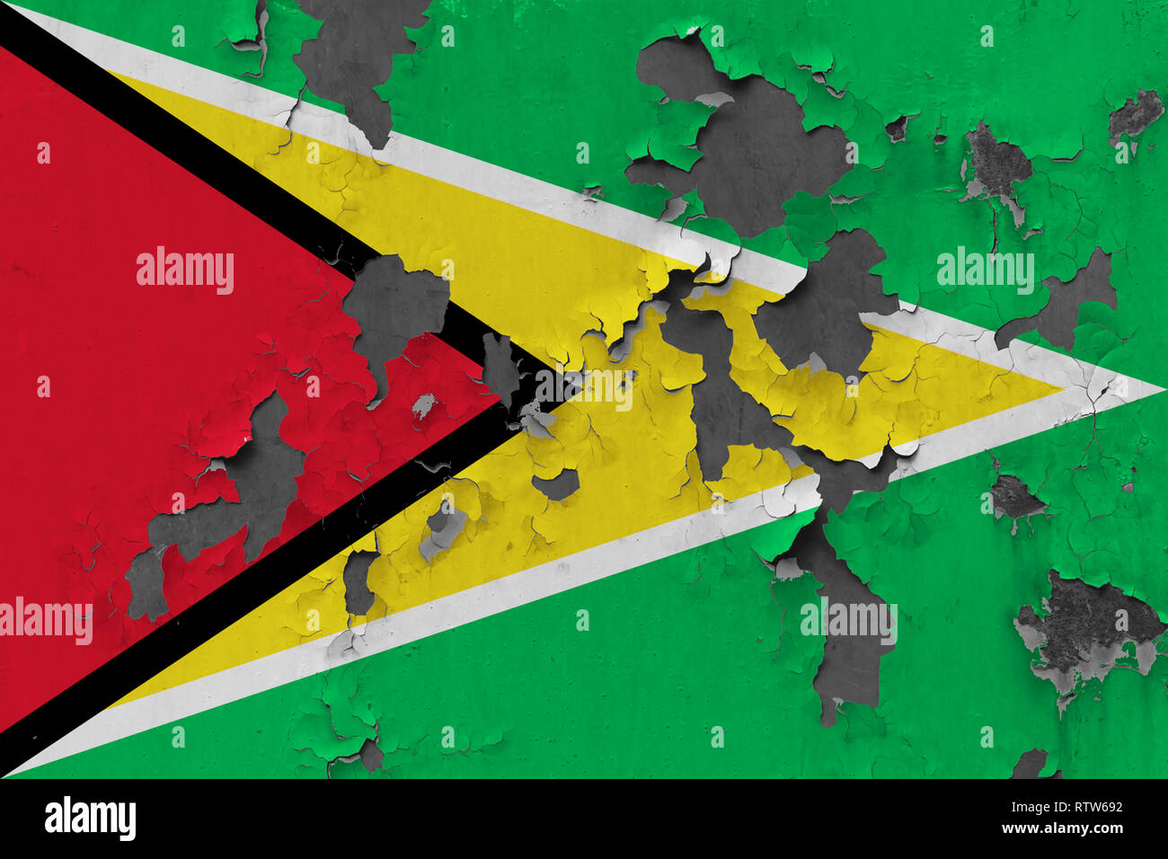 Close up grungy, damaged and weathered Guyana flag on wall peeling off ...