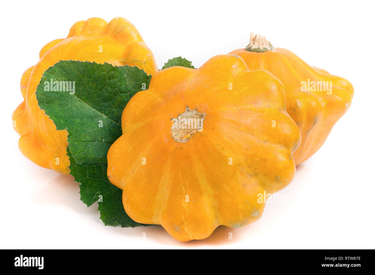 three yellow pattypan squash with leaf isolated on white background ...