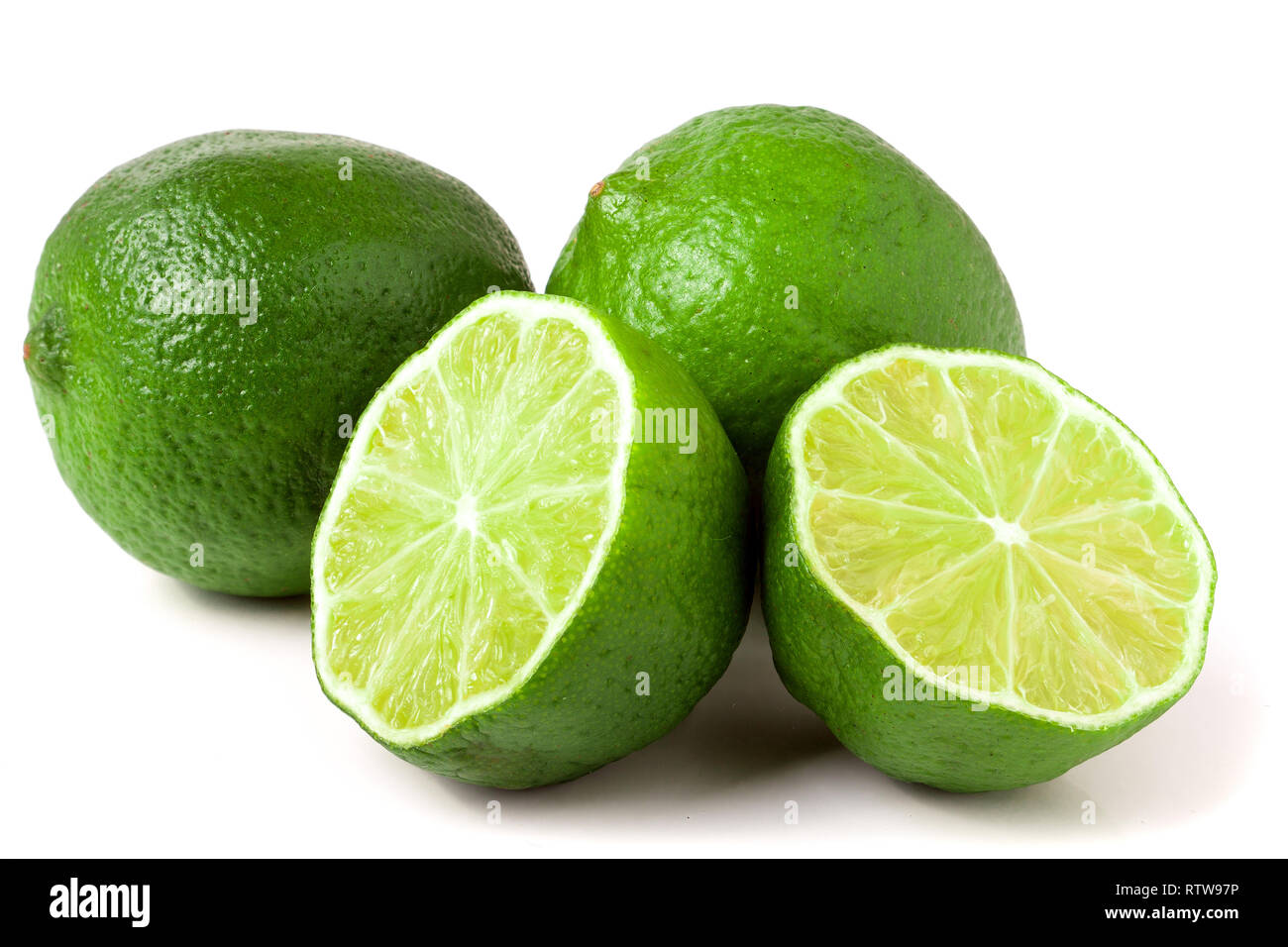 two limes with halves isolated on white background Stock Photo - Alamy