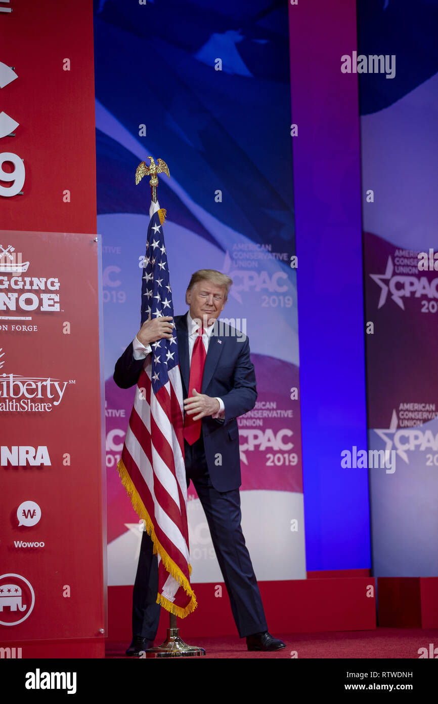 U.S. President Donald Trump hugs the U.S. flag during CPAC 2019 on ...