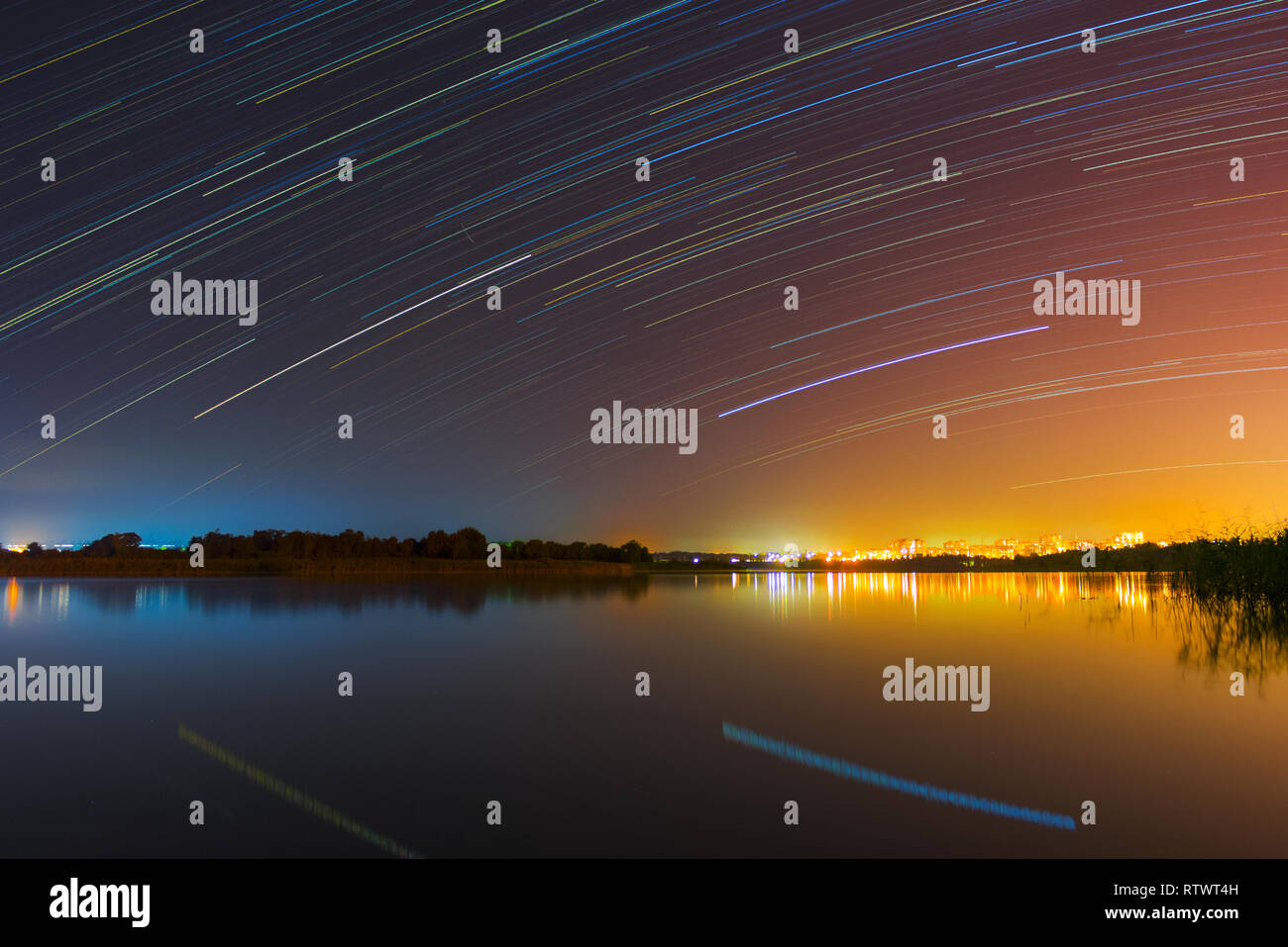 A star trails above the river. Long exposure photography. A city far ...