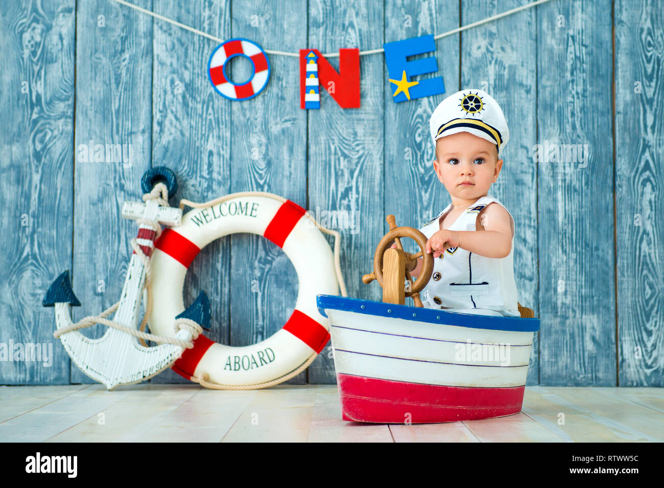 Photoshoot for a boy of one year. Little sea captain, sailor on toy ...