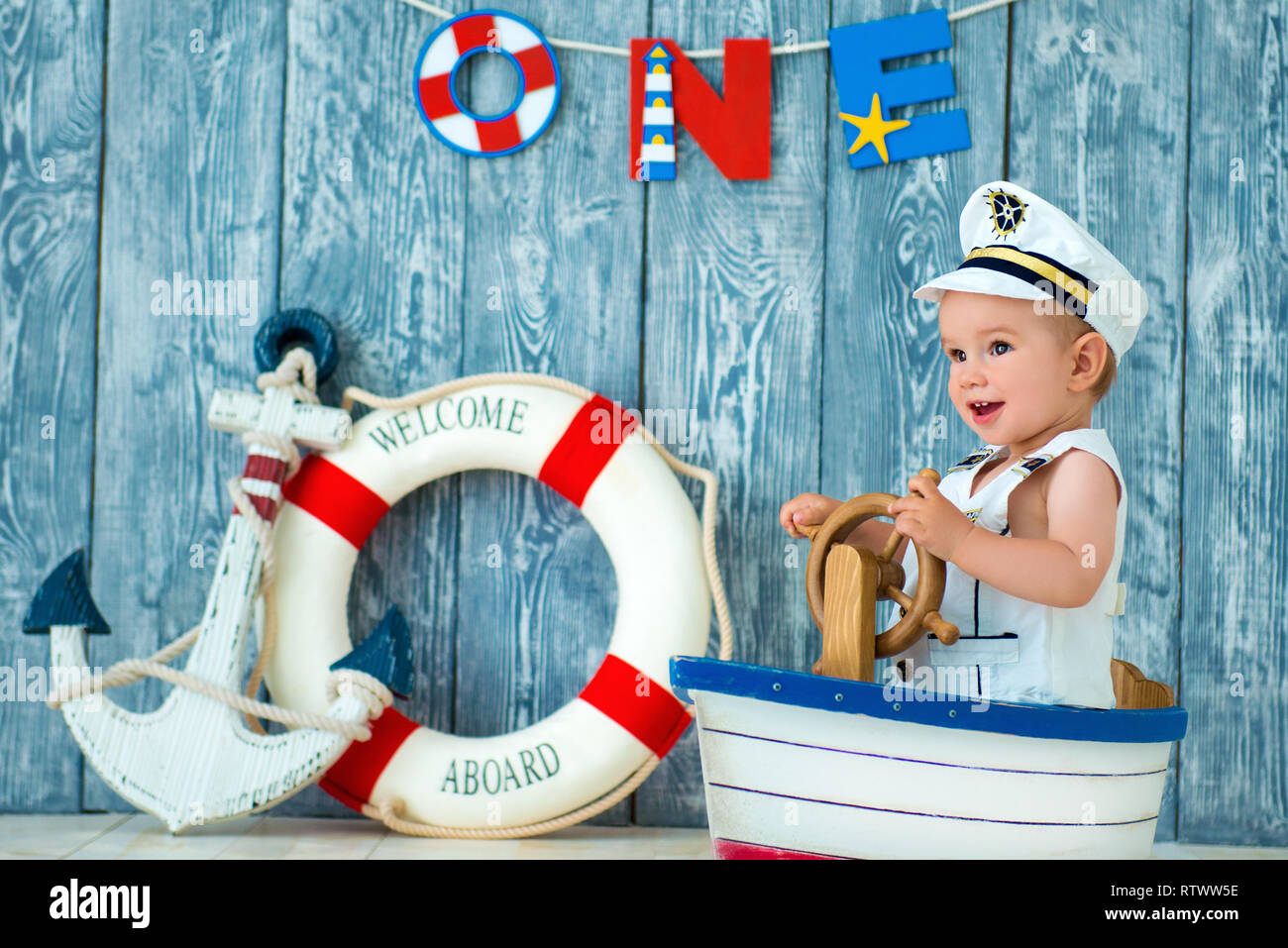 Photoshoot for a boy of one year. Little sea captain, sailor on toy ...