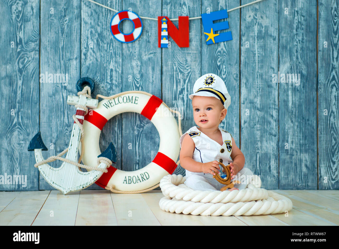 Photoshoot for a boy of one year. Little sea captain, sailor on toy ...