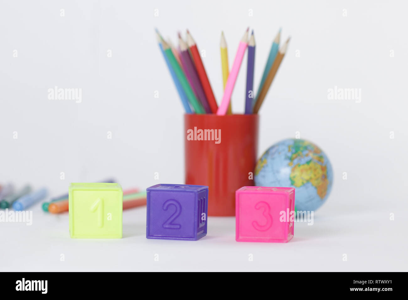 cubes with numbers on blurred school supplies background Stock Photo ...