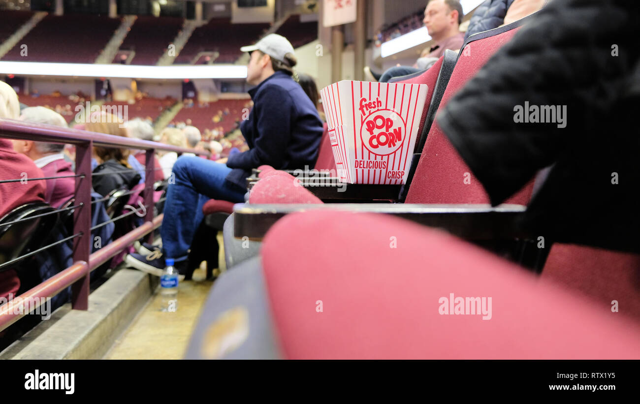 Popcorn tub on an arm rest in a sports arena; popcorn tub between seats ...