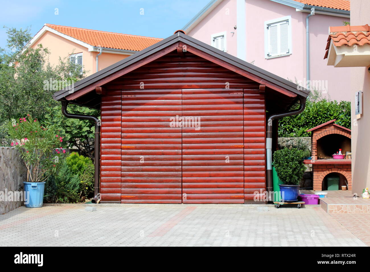 Backyard wooden storage structure with stone tiles in front surrounded ...