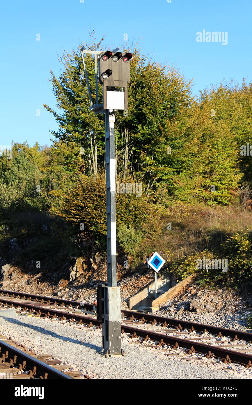 Black and white tall metal pole with railway signal lights on top ...