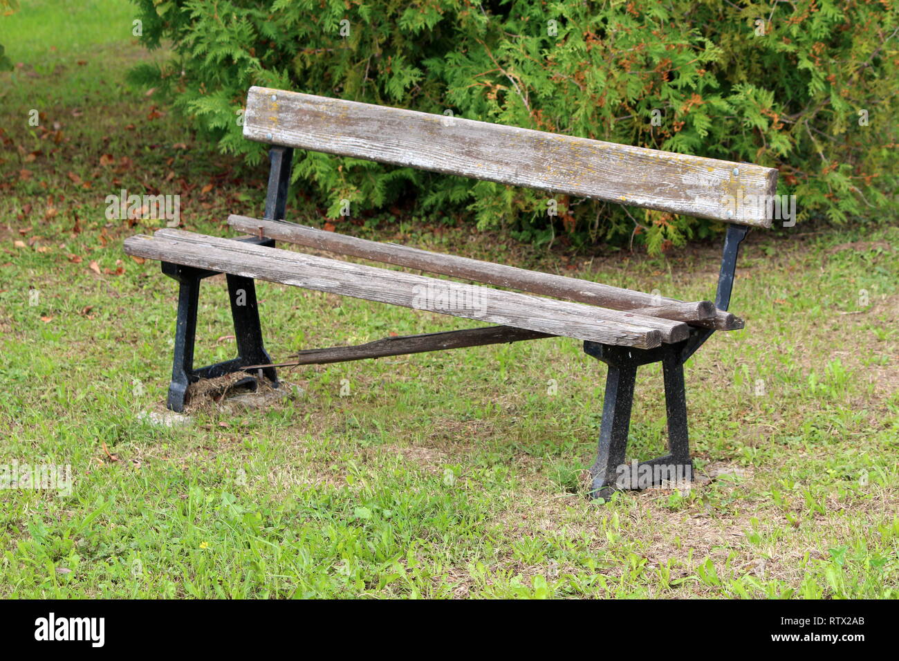 Broken old public bench with dilapidated wooden boards and strong metal ...