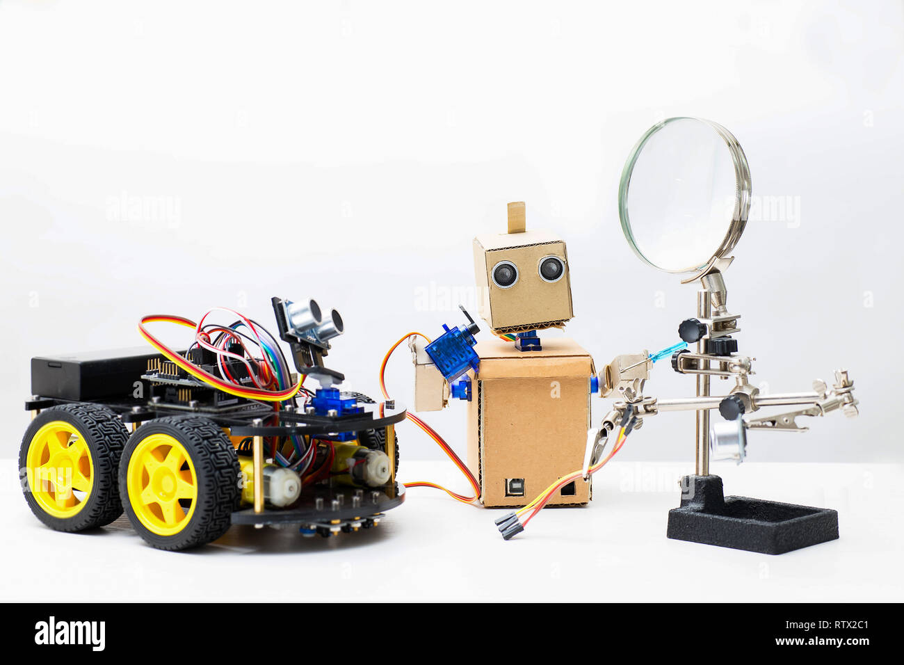 Two robots stand on a table on a white background Stock Photo - Alamy