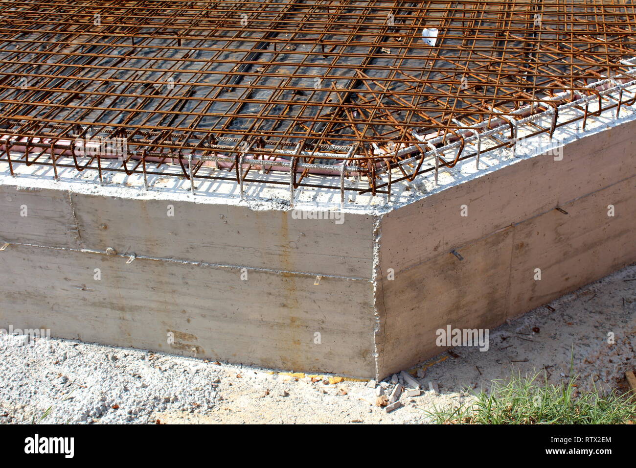 Concrete building foundation with densely laid rusted metal ...