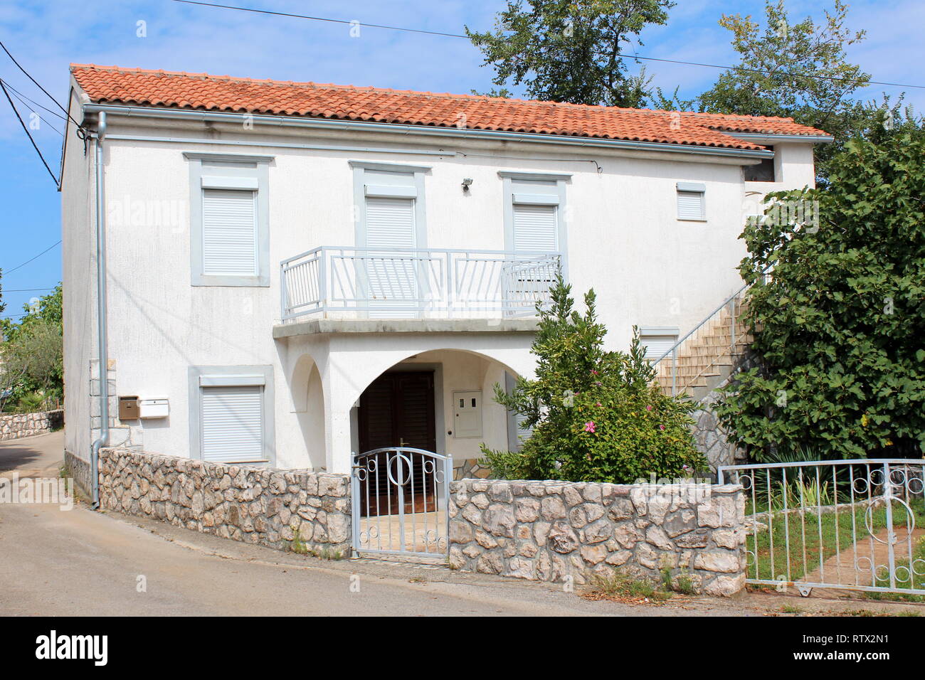 Family house built on street corner with closed window blinds and small ...
