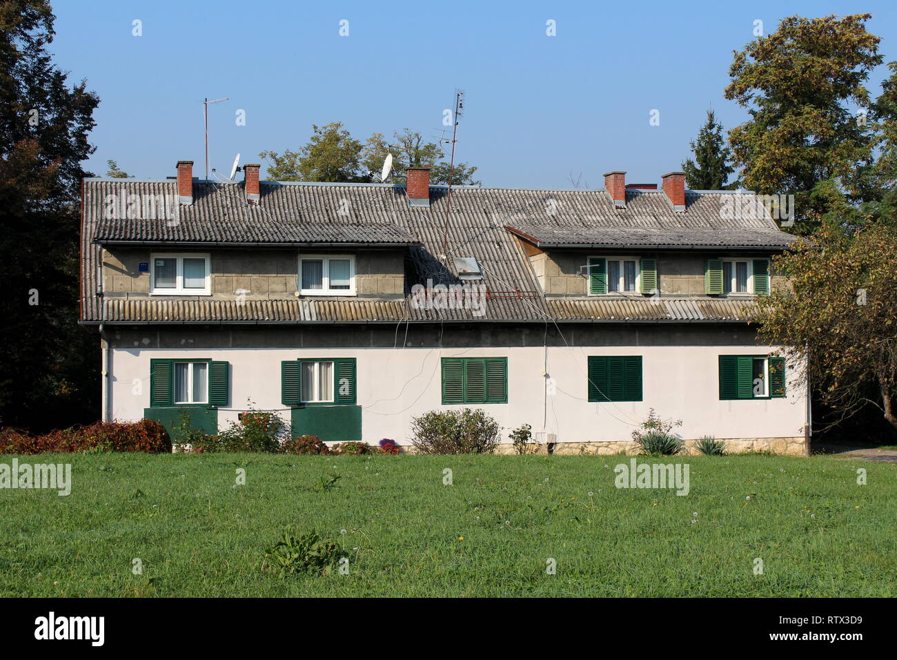 Long family house with four apartments and wooden blinds on windows ...
